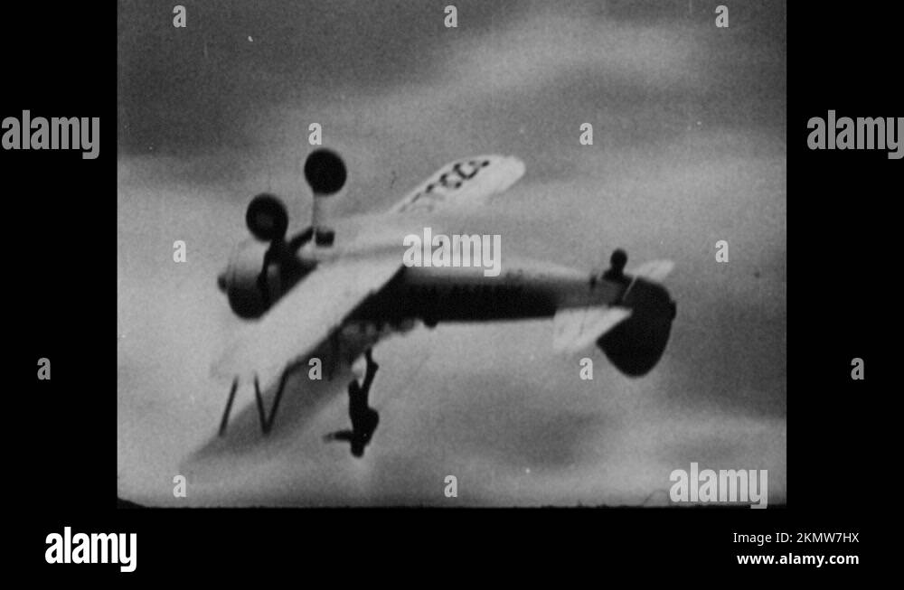 1960s: Pilot in Wright Brother's plane. Airplane flies upside down ...
