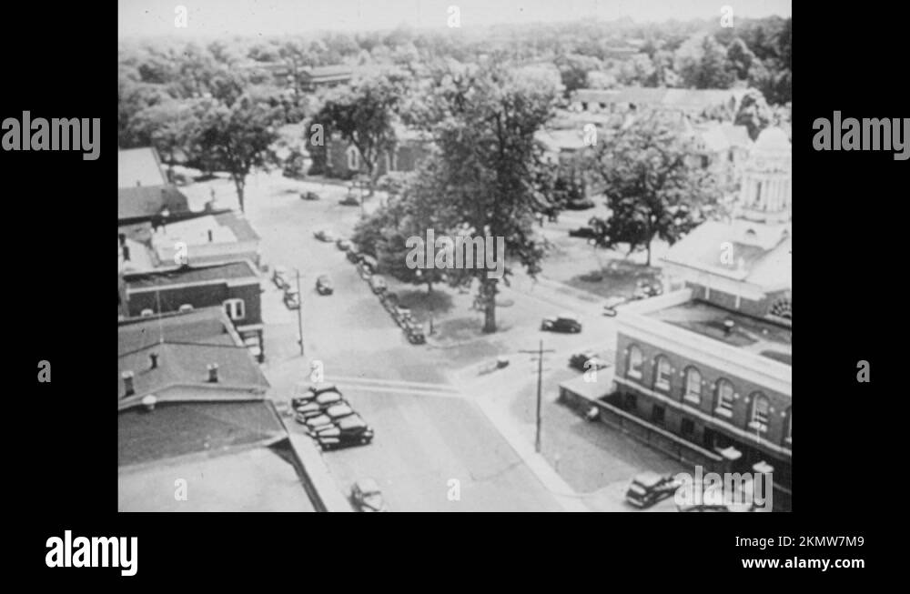 1950s: Town square. Car driving down road. Police officer directing ...
