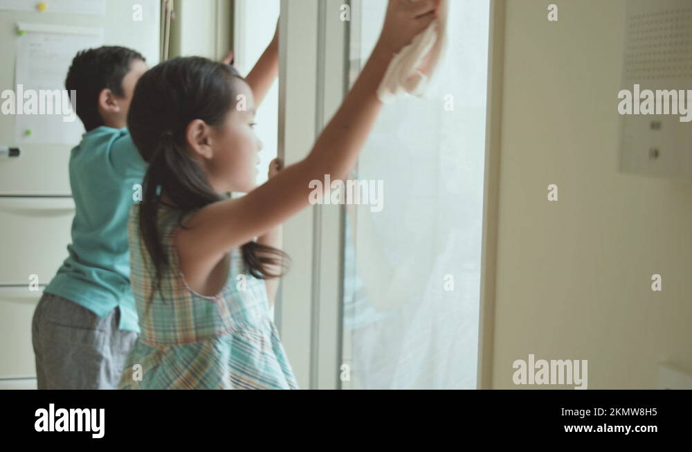 Brother and sister cleaning the window Stock Video Footage - Alamy