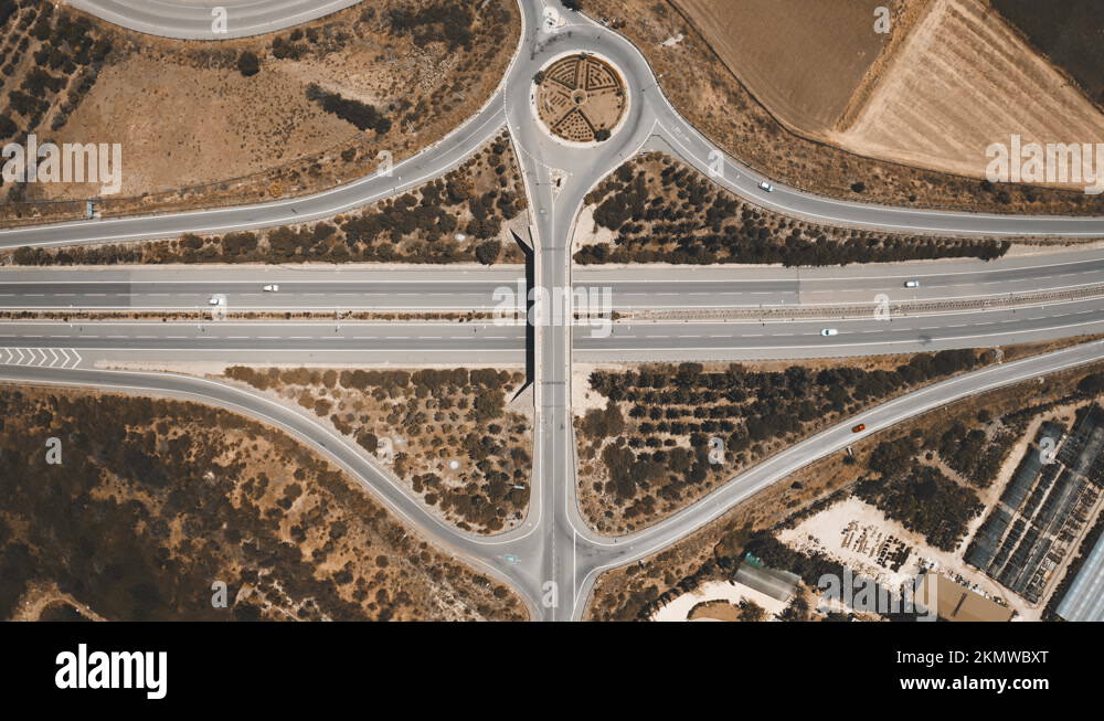 Multi-level round junction highway in valley, top down. Dull landscape ...