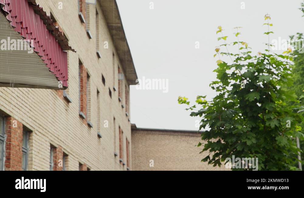 Jets of rain pour down from roof and canopy of old brick building Stock ...