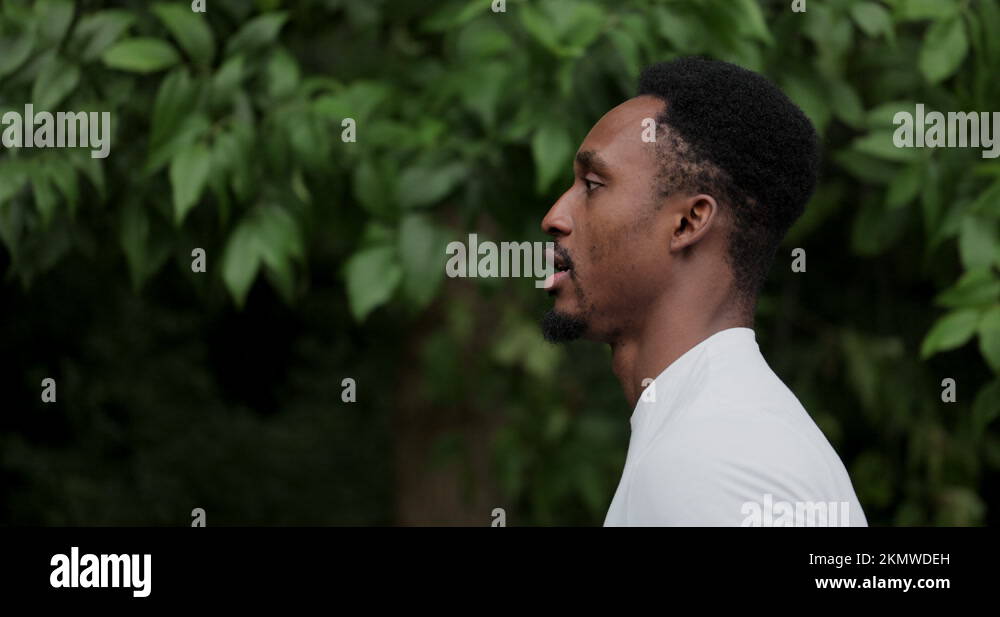 Close up African american man running inside the park on a sunny day ...