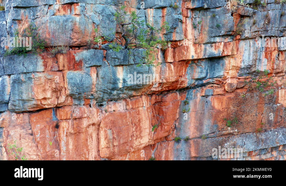 Red rugged cliff - sedimentary rock mountain formation. Vertical rough ...