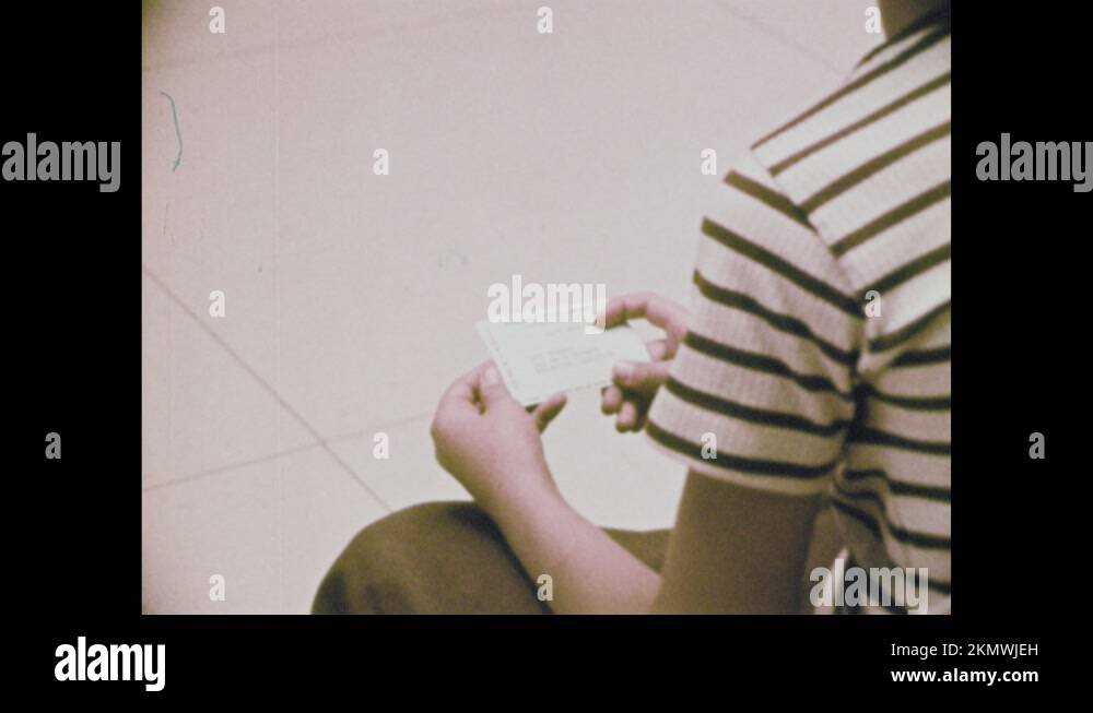 1970s: Woman in library talks. Boy holds library card in hand. Three ...