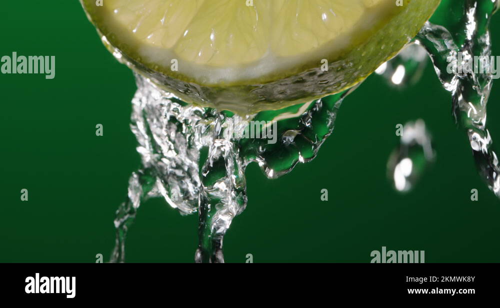 Fresh water running down slice of lime fruit. Healthy organic citrus ...