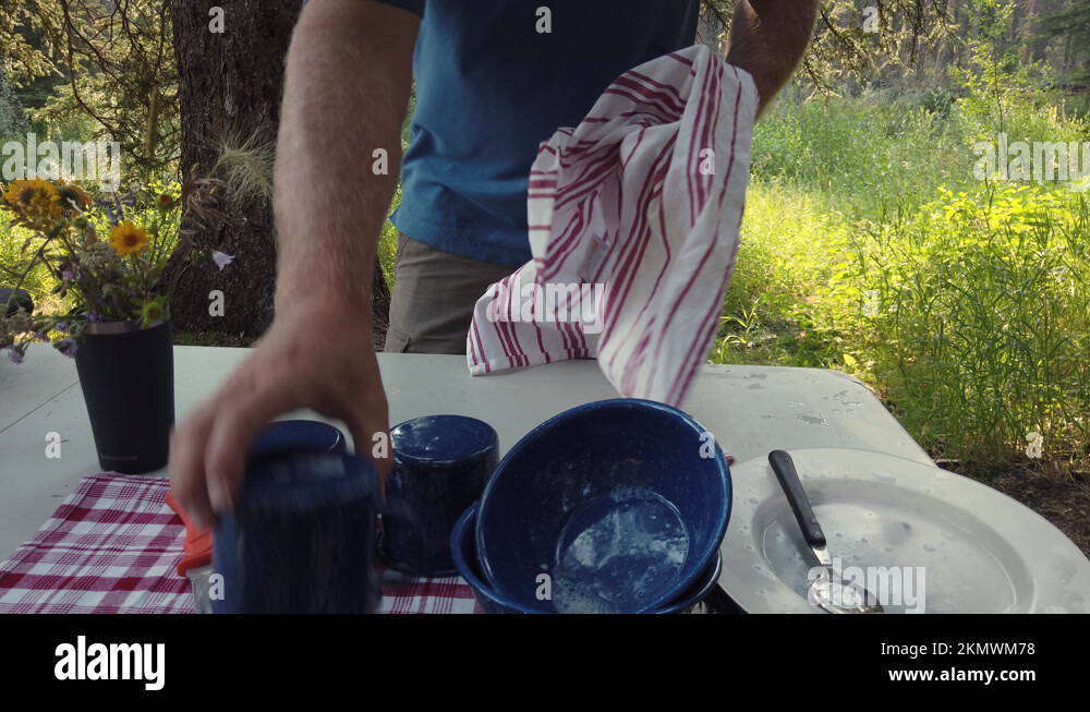 Cleaning up the dishes after eating at the campsite Stock Video Footage ...