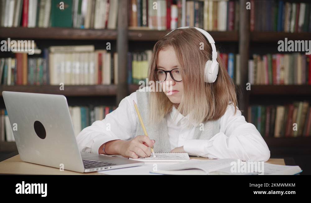 Young female pupil watching lesson online and studying from home. Young ...