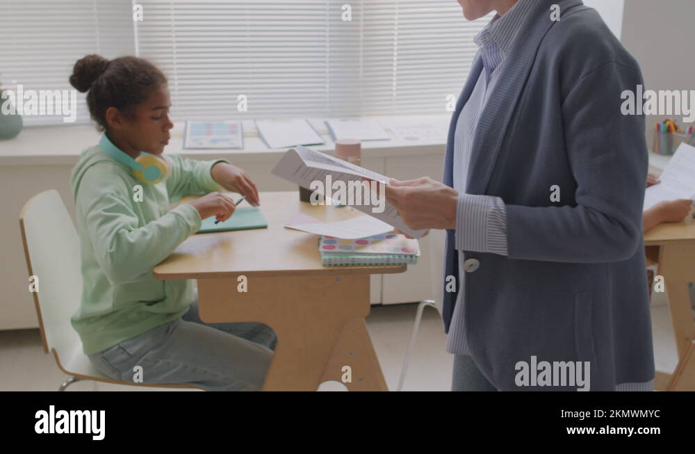 Teacher Giving Test Sheets to Children in Class Stock Video Footage - Alamy