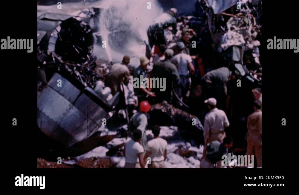 1960s: Wreckage of bomber plane off runway, people putting out fires ...