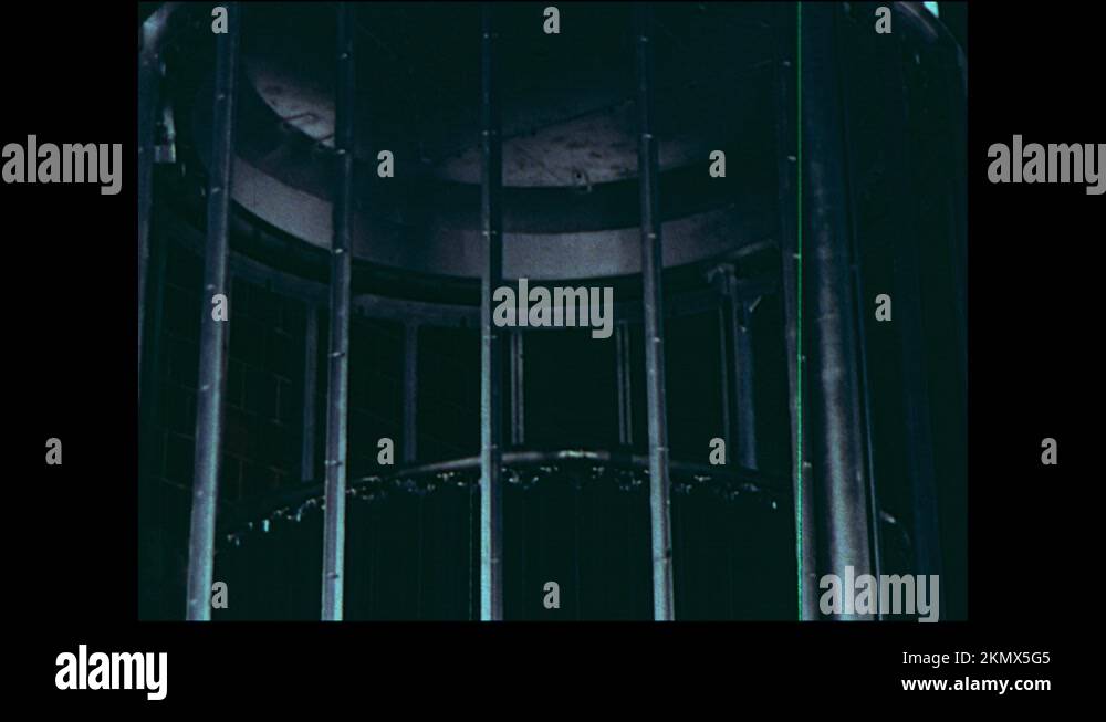 1960s: Parts of atomic container sit on display. Man observes large ...