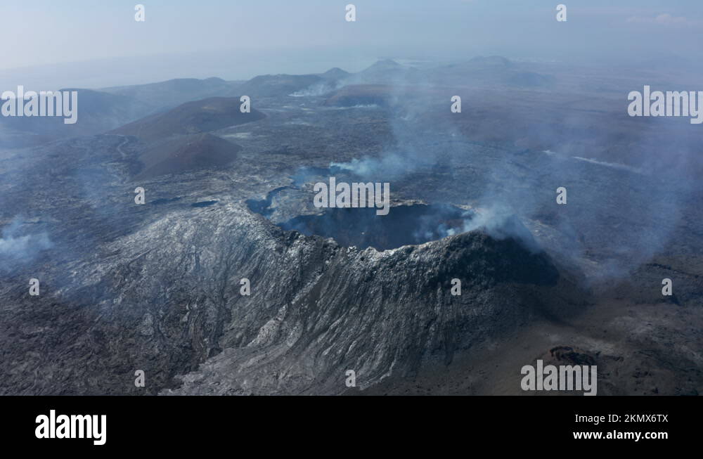 Fly above volcano after eruption. Aerial view of top of mountain with ...