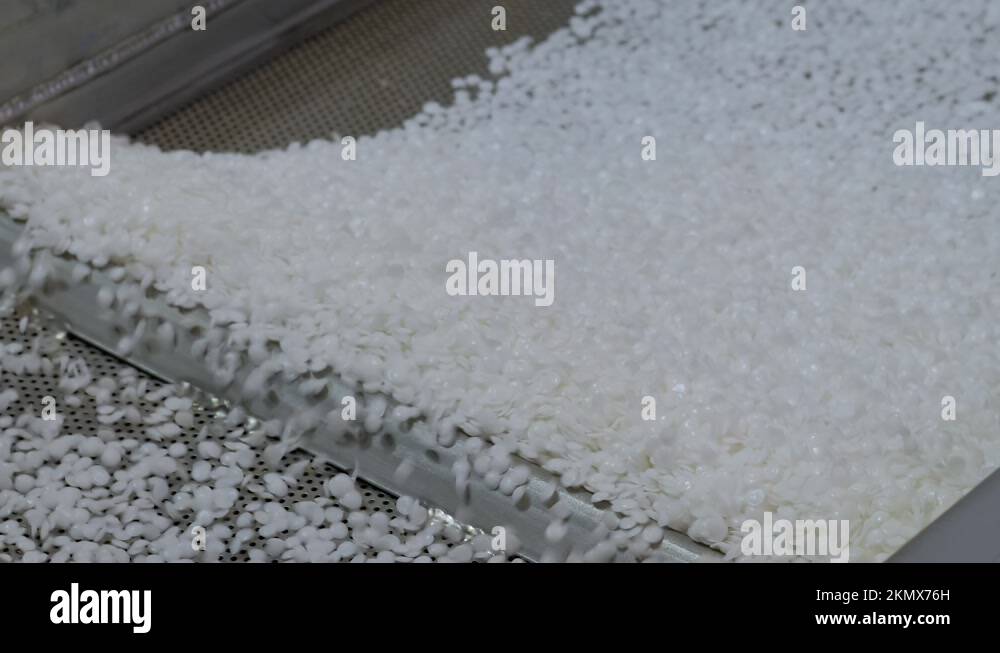 Close up: recycled plastic granules on automatic shale shaker, conveyor ...
