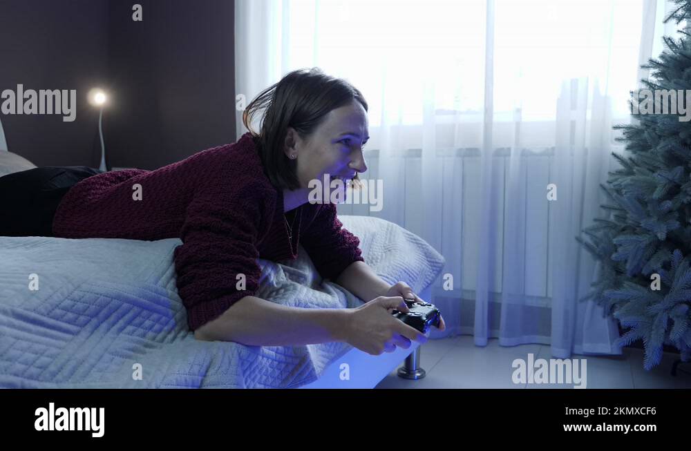 Girl playing video games on console using wireless controller joystick ...