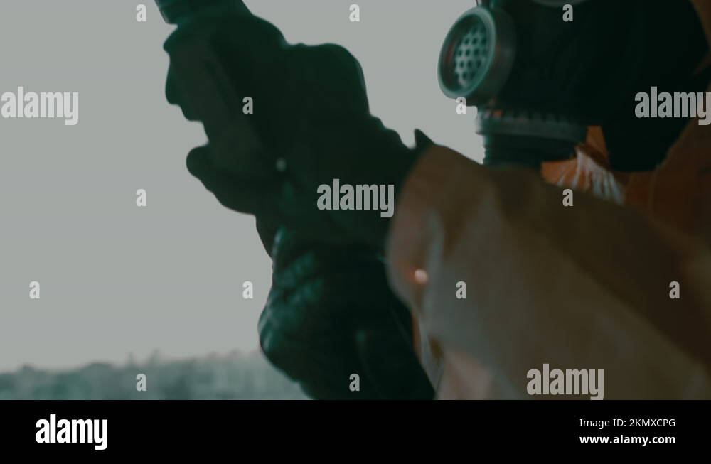 man in protective suit, gas mask loads rifle, close-up. Consequences of ...