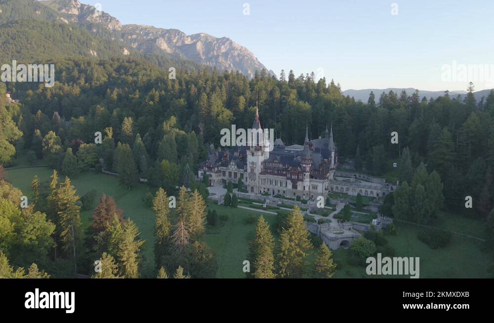 Drone flying around the Peles Castle in the shadows during sunrise in ...