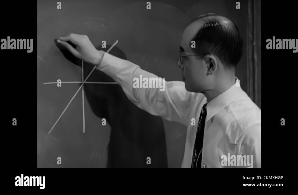1950s: Yukawa Hideki draws a diagram on a chalkboard. Student watches ...