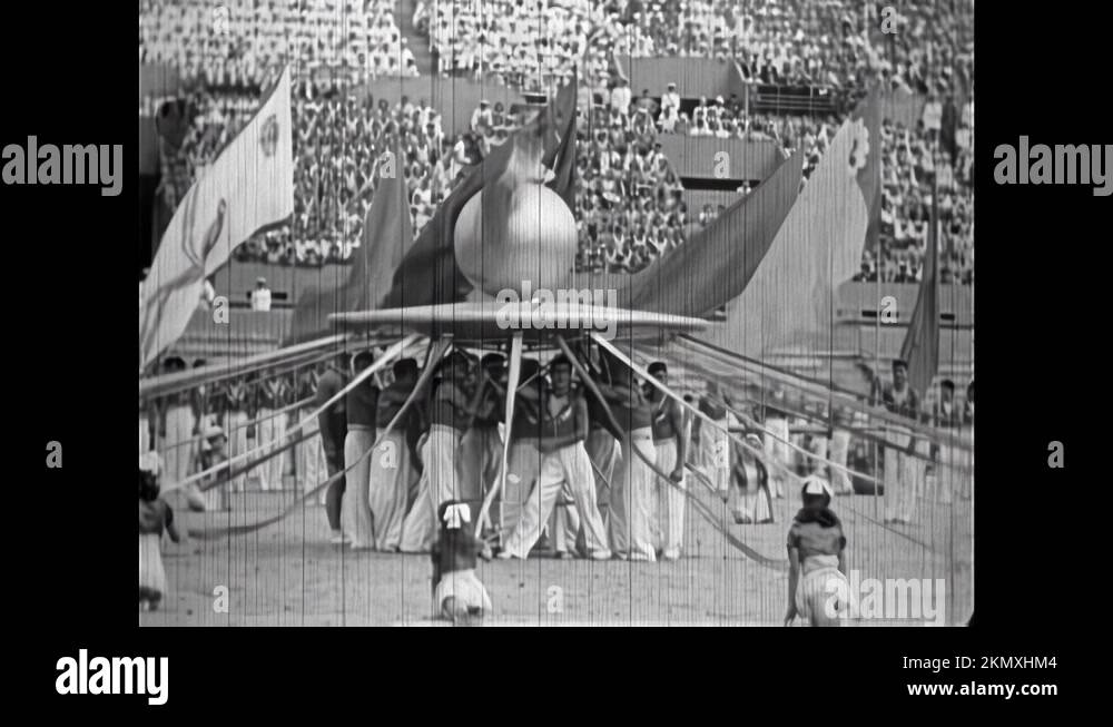 1940s: Group in costume doing acrobatic display in stadium. Men doing ...