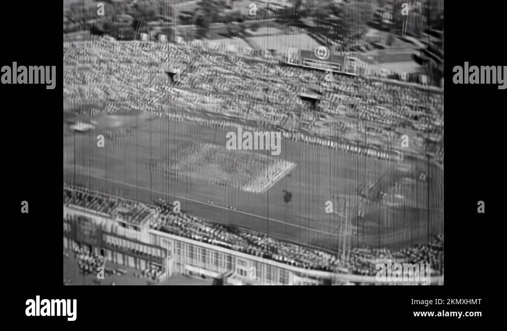 1940s: Long shot, people doing choreographed display in stadium. Aerial ...
