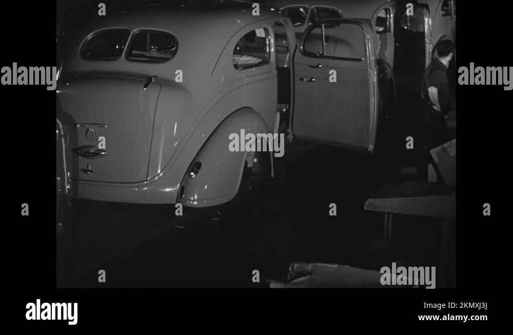 1950s: Interior automobile factory. Three cars on an assembly line ...