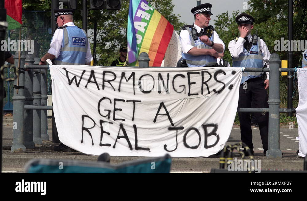 Metropolitan police liaison officers stand behind a white banner with ...