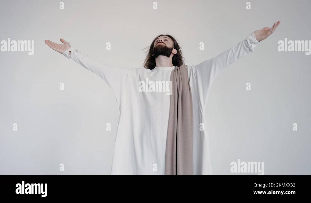 Jesus raised his hands and head in prayer on a white background. Studio ...