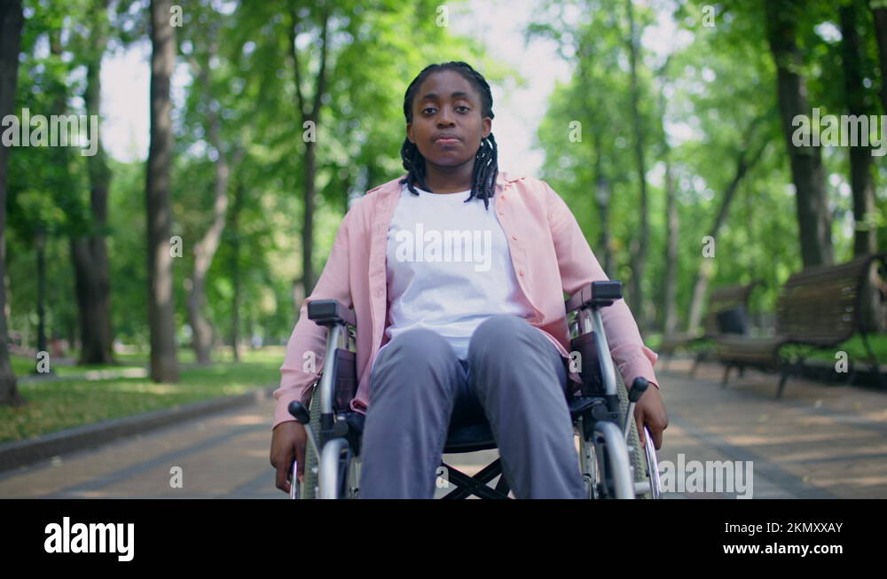 Sad black woman sitting in wheelchair in park, facing life with ...