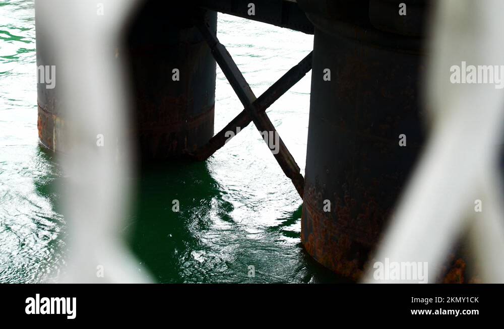 Sea water splashing beneath submerged concrete bridge foundation ...