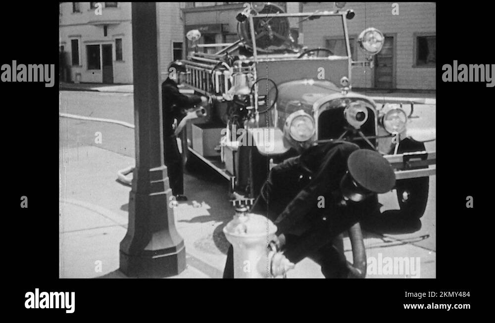 1940s: Firefighters pull hose from back of fire truck, attach hose to ...
