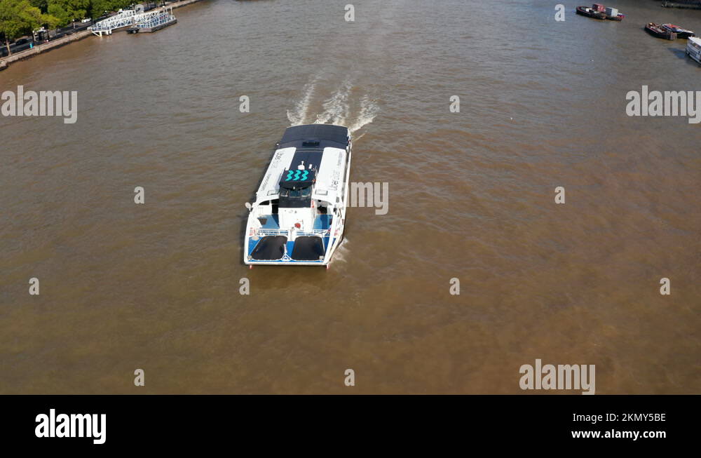 Boat floating against. Tilt up reveal of embankments, bridge and modern ...