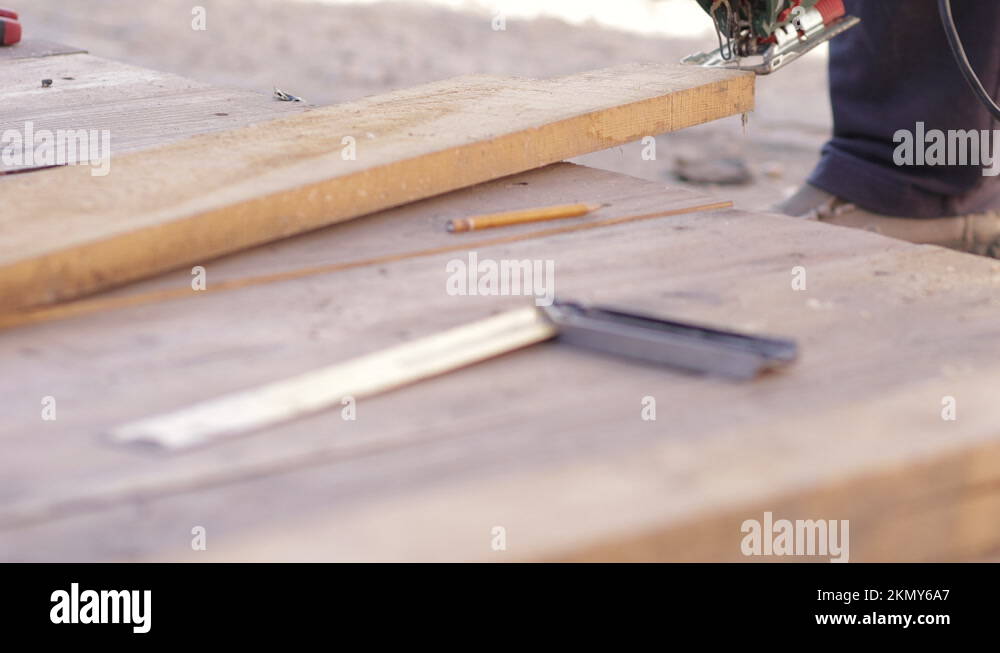 a man saws a board with an electric jigsaw, carpentry work Stock Video ...