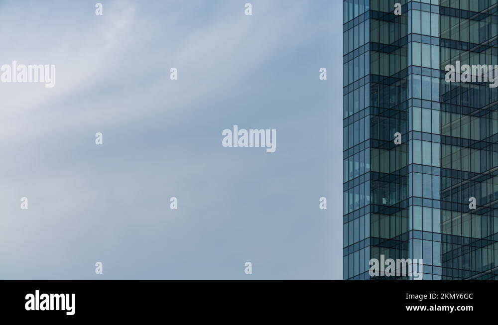 Timelapse glass skyscraper high office building facade, moving clouds ...