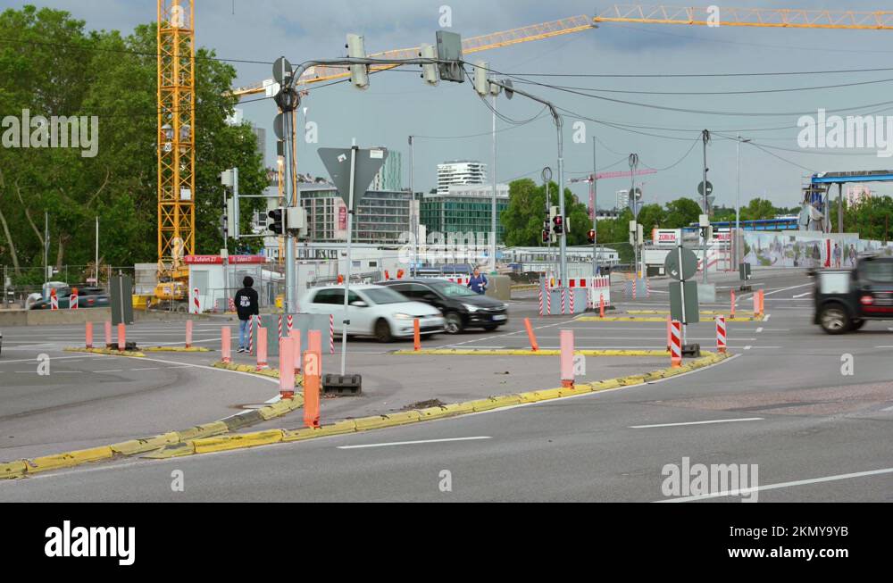 Busy intersection with cars and people obstructed by construction site ...