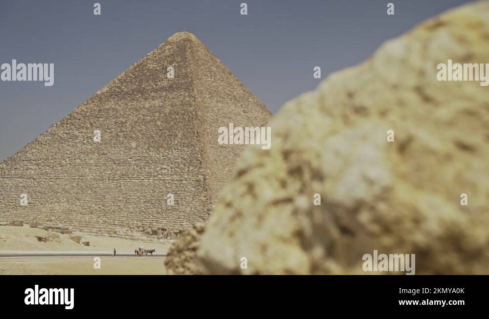 Trucking shot around rock to reveal one of the Great Pyramids of Giza ...