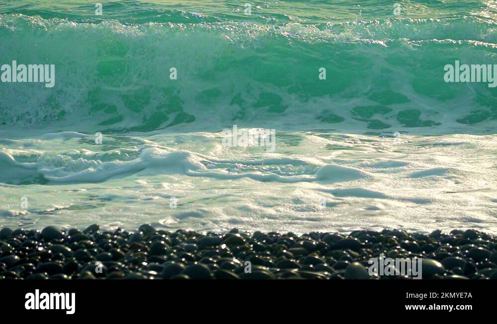 Waves forming and crashing onto a pebble beach. Filmed in the ...