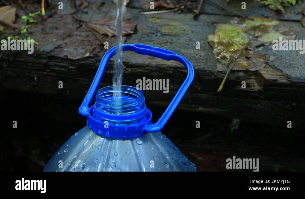 stream of drinking spring water pours into a plastic bottle Stock Video ...