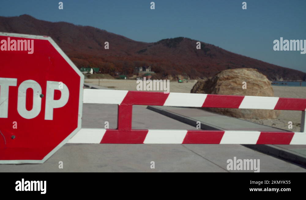 Sliding close view of road gate with red sign "Stop" at the beach Stock ...