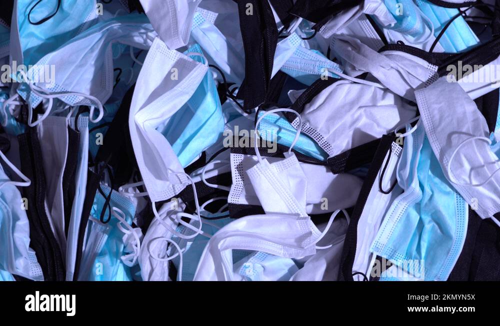 Medical masks on the table. Pile of used personal protective equipment ...