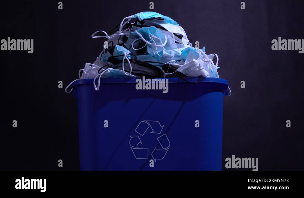 Medical masks in the recycle bin. Reusing and recycling of used ...