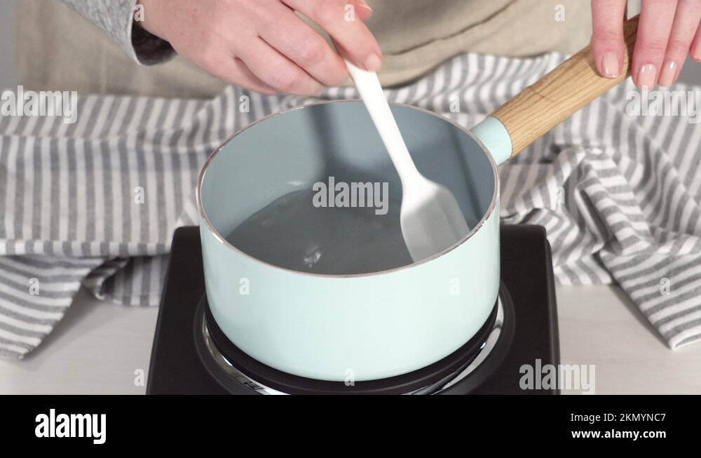 Preparing sugar syrup in a small saucepan over an electric pan Stock ...