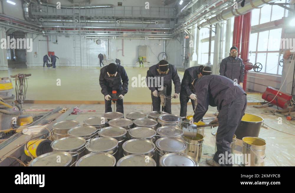 Working process at a construction site. Workers stir up the bulk floor ...
