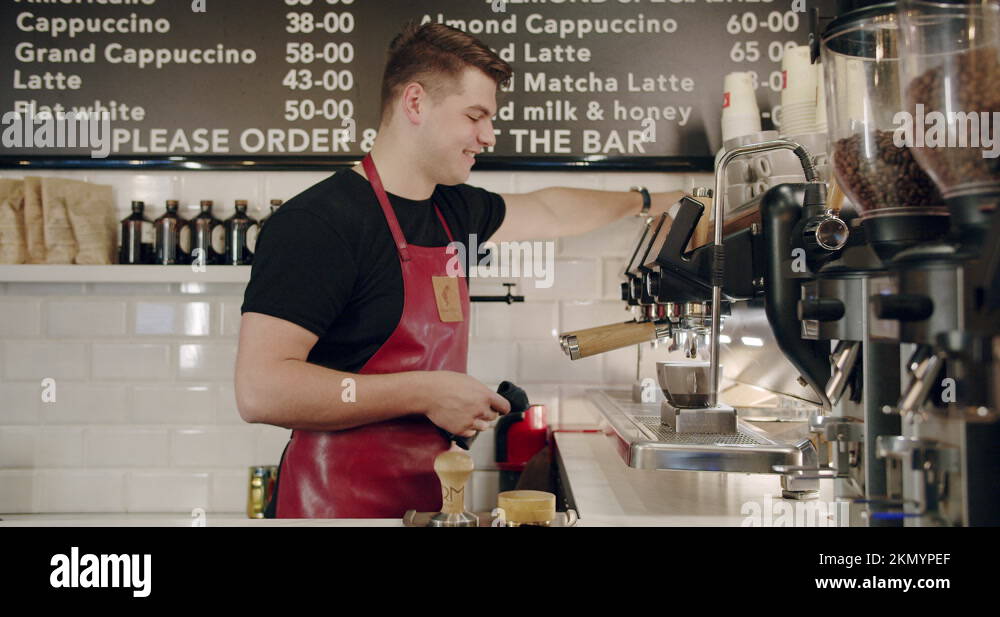 Barista at work smile and make a cup of strong coffee in a modern ...