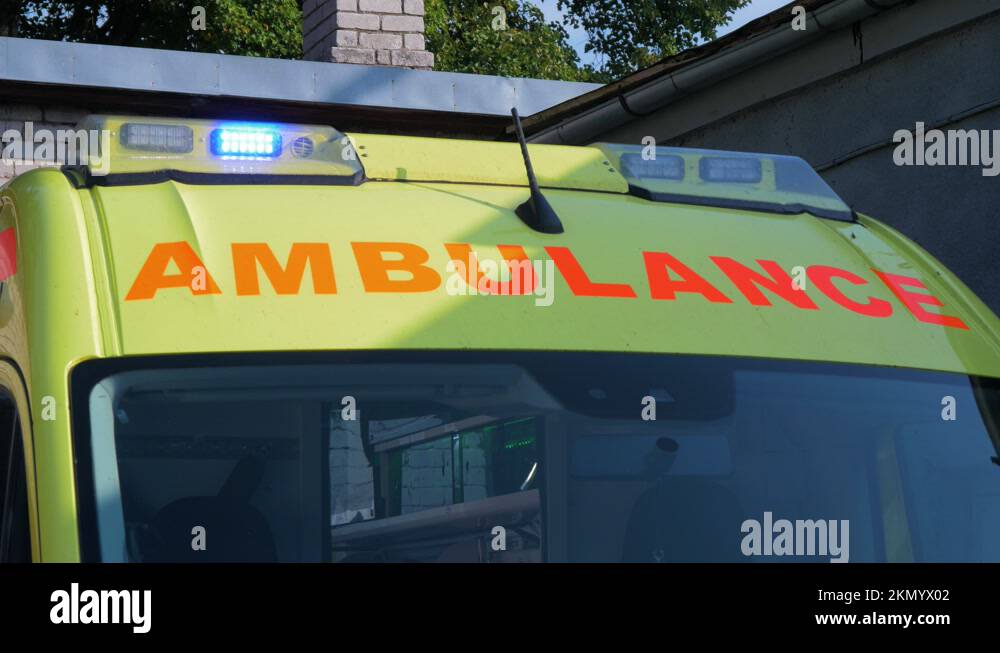 The roof of yellow paramedic ambulance vehicle parked outside, blue ...