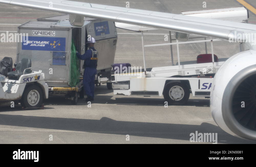 Baggage Handler Loading Luggage Onto An Airplane Through A Conveyor ...