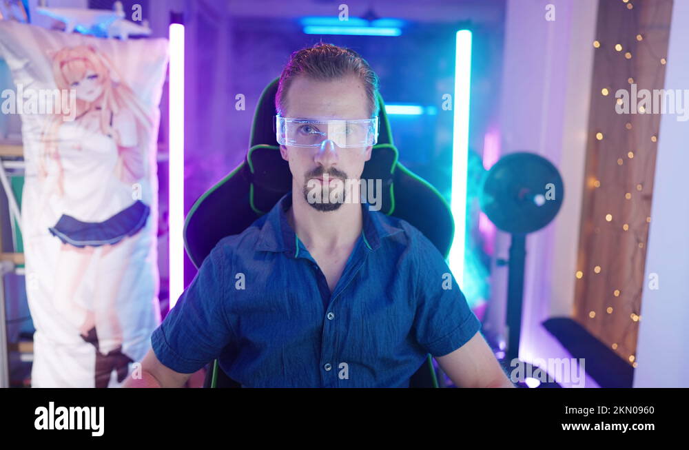 Attractive man geek portrait in gaming room with neon lights and ...