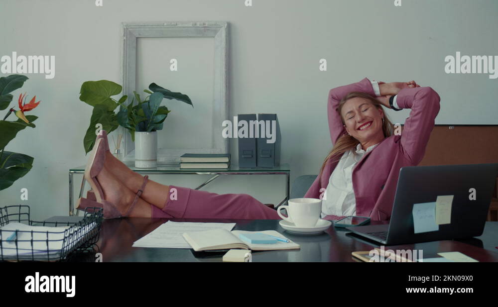 Work and life balance. Happy successful beautiful female boss with legs ...