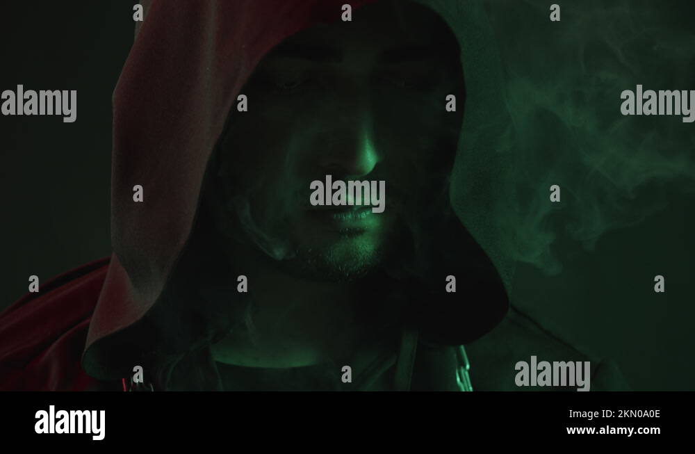 Evil exorcist wearing black suit on dark background. Portrait of wicked ...