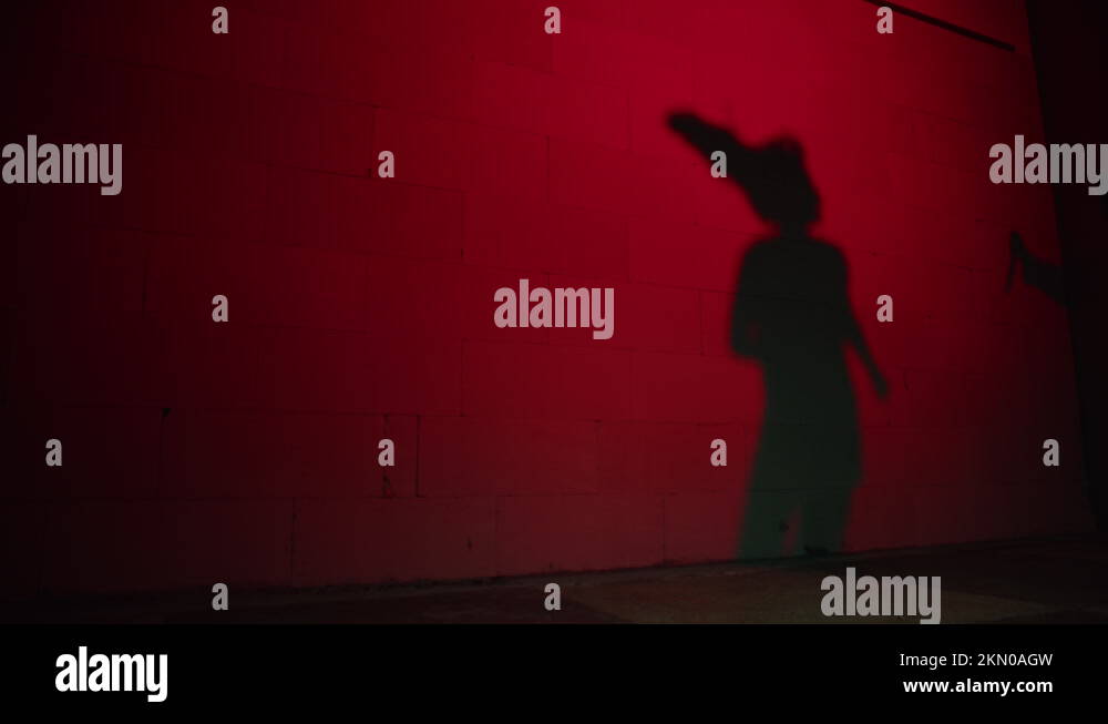 Creepy death silhouette running for victim with knife on red background ...