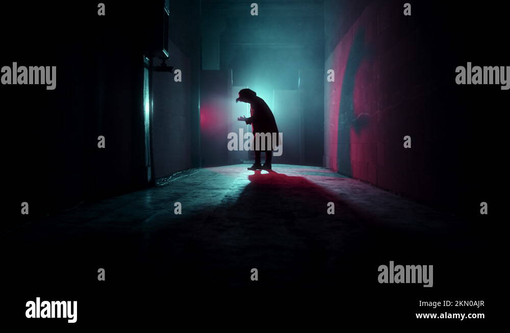 Demon with horns conjuring in corridor. Silhouette of devil in darkness ...