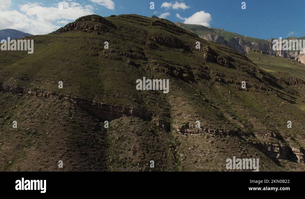 Unusual mountains with steep limestone slopes over gentle green hills ...