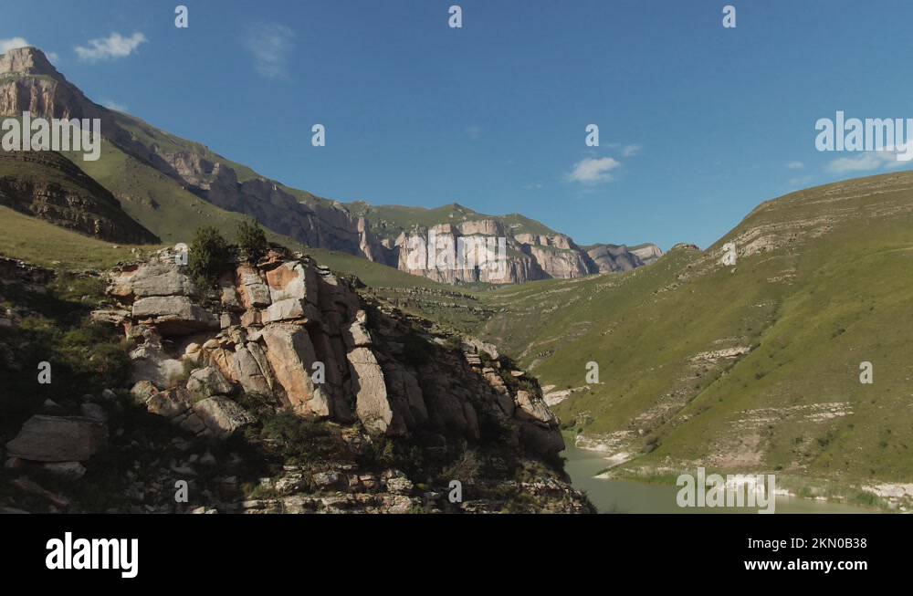 Unusual mountains with steep limestone slopes over gentle green hills ...